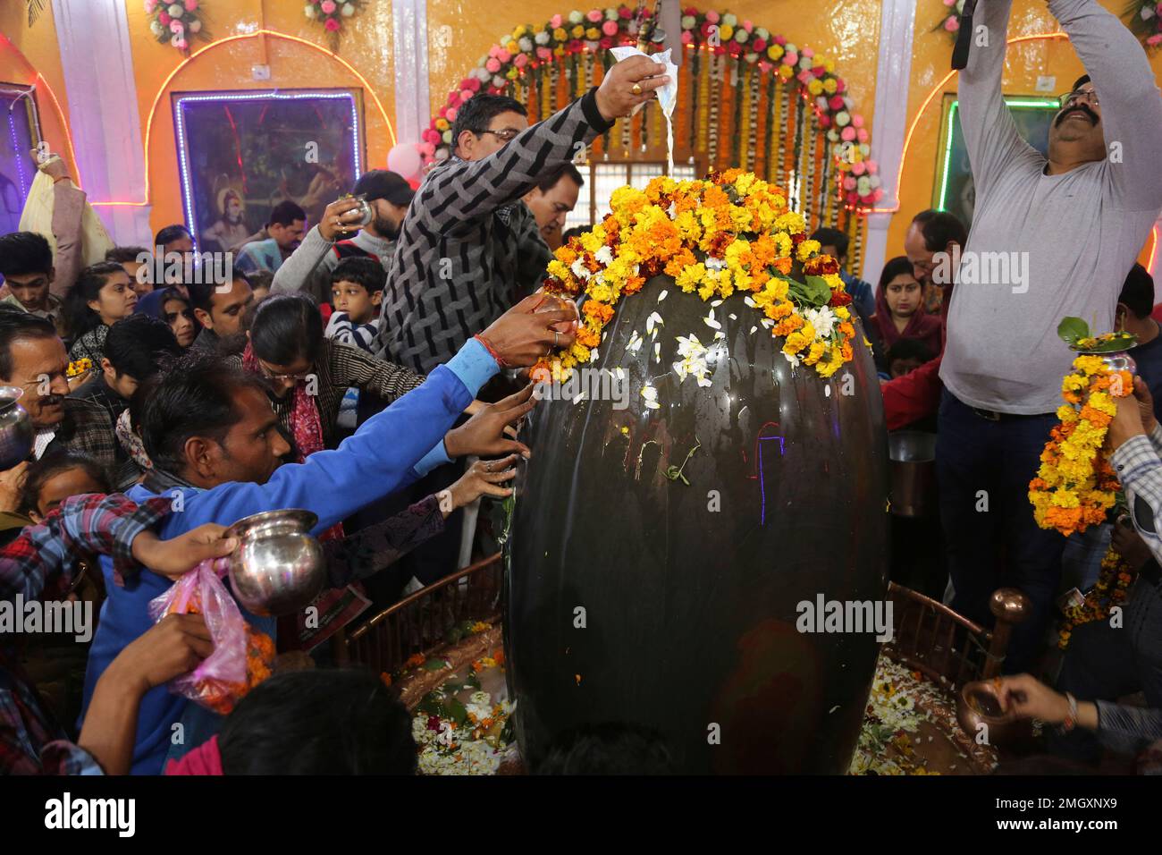 Indian devotees performs ritual in front of a Shivling, a ...
