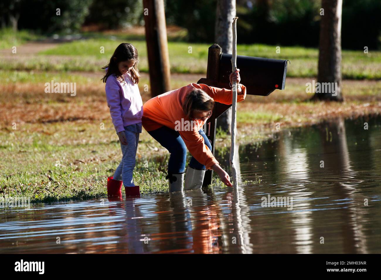 Barbara Beavers marks a pole used to measure the flooding on her street ...