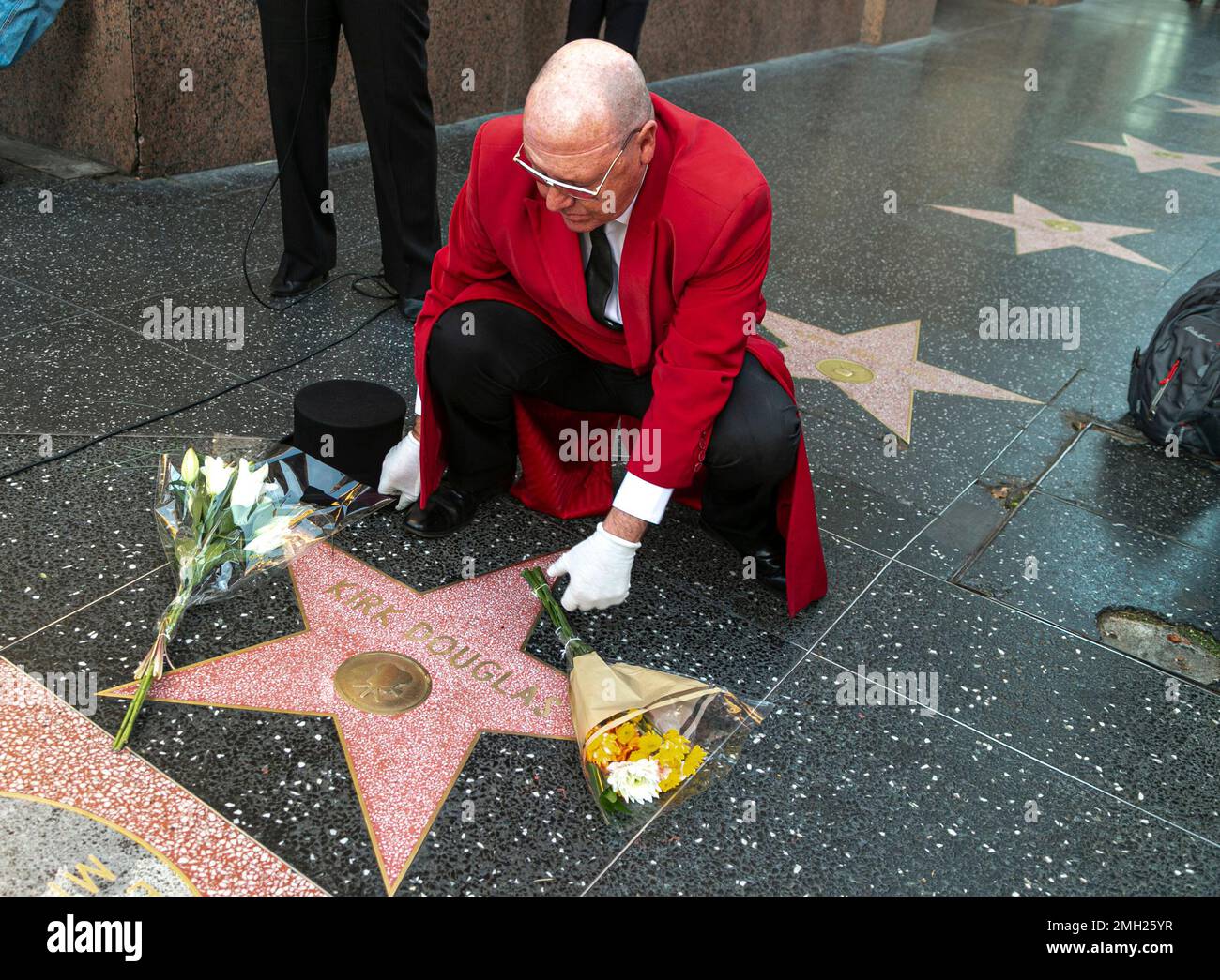 Unofficial Hollywood ambassador Gregg Donovan sets flowers on the Walk ...