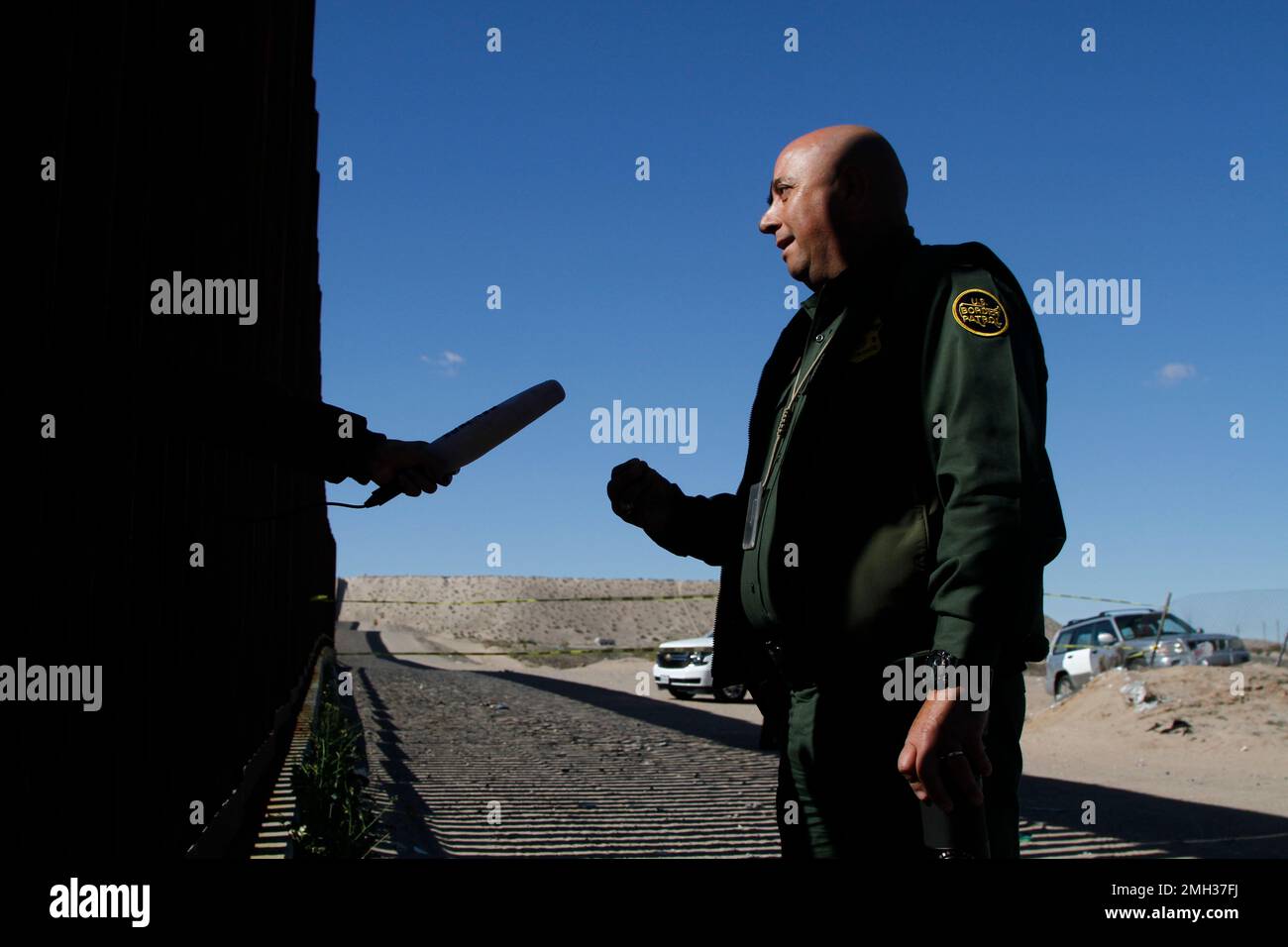 A journalist in Anapara, Mexico, sticks a microphone through a border ...