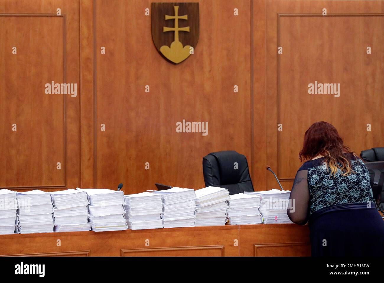 A woman arranges case files in a courtroom in a courtroom ahead of the ...