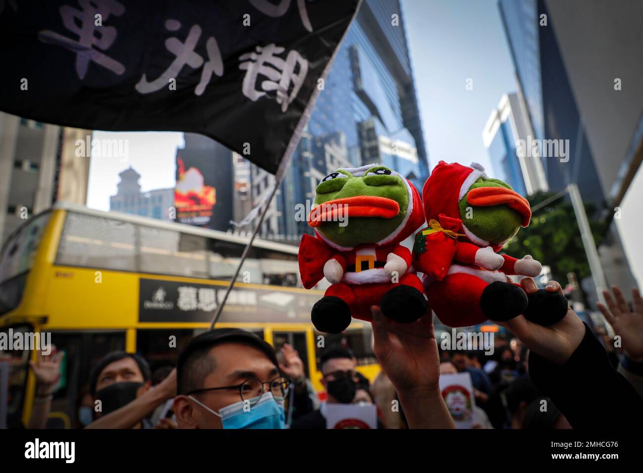 Pro-democracy supporters and office workers wave a flag and hold the ...