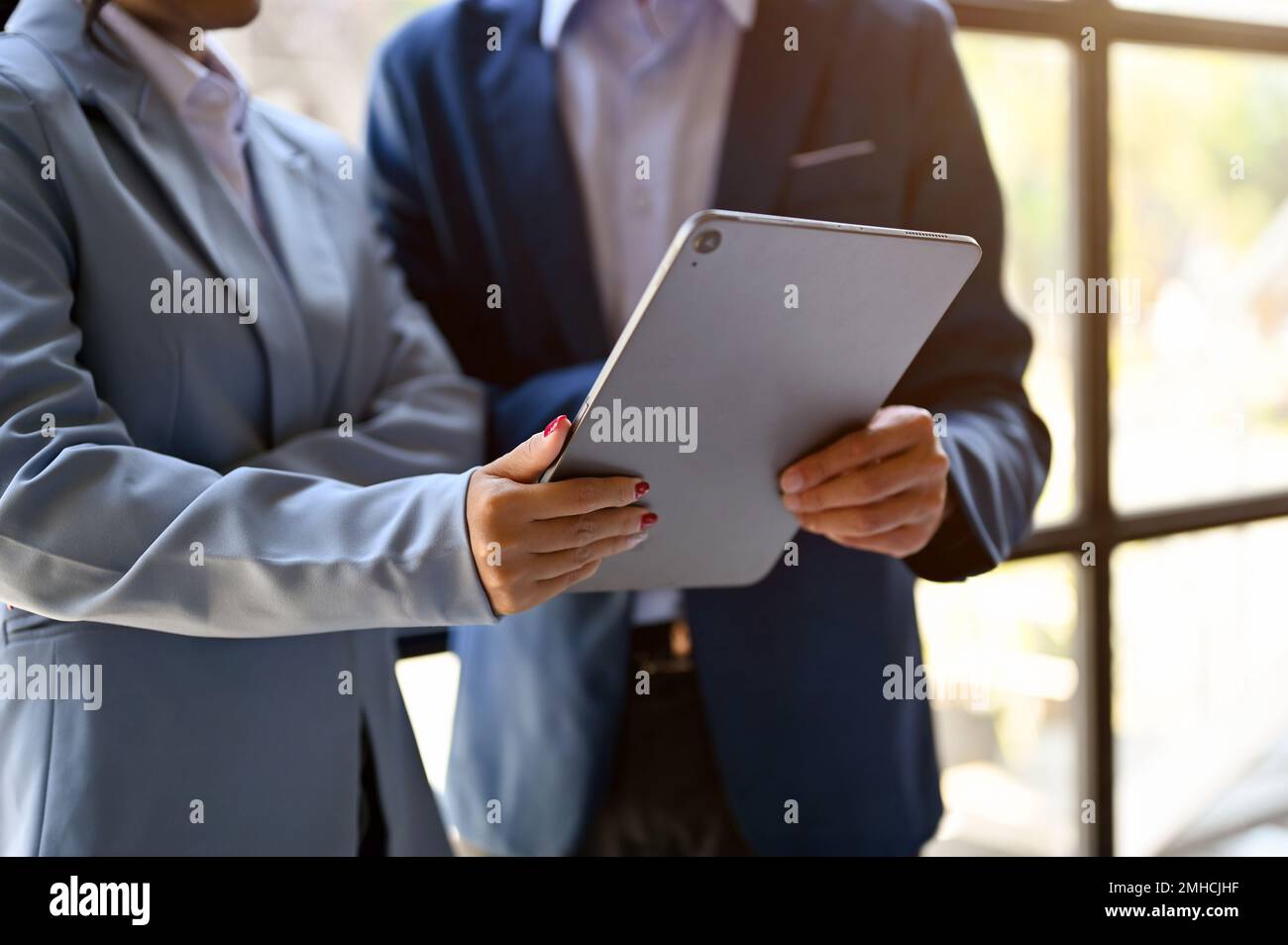 Zugeschnittenes Bild von zwei Geschäftsleuten, die im Büro auf den ...