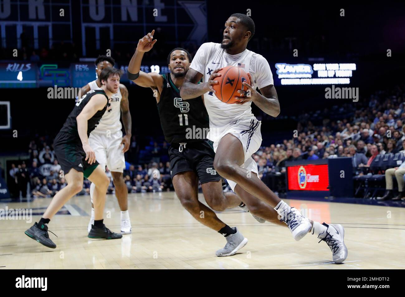 Xavier's Naji Marshall, right, drives against Green Bay's JayQuan ...