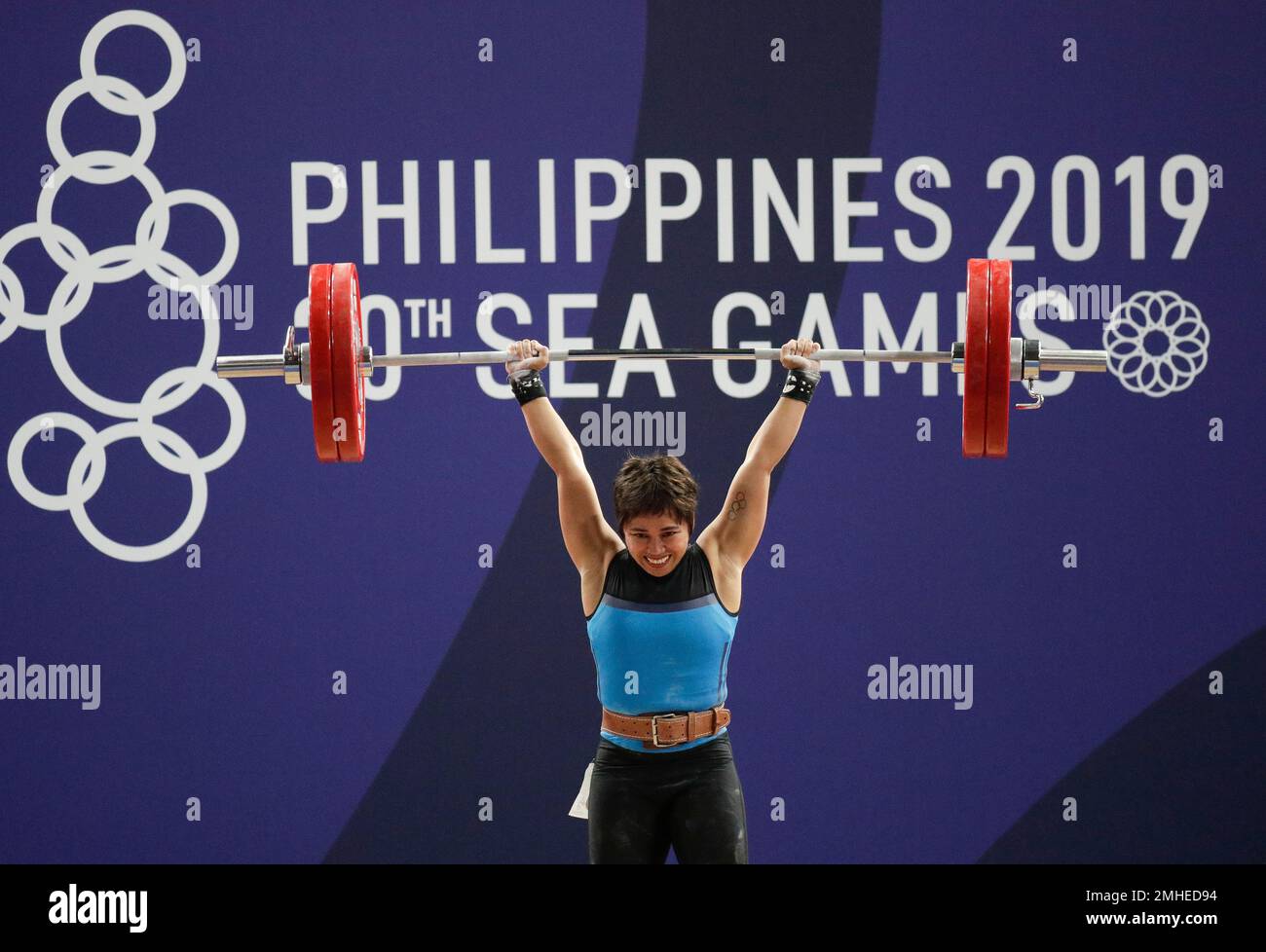 Gold medalist, Philippines' Hidilyn Diaz smiles as she lifts during the women's 55kg ...