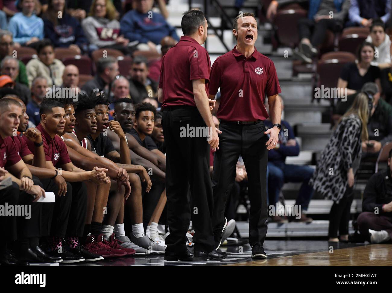 Massachusetts head coach Matt McCall, right, reacts and is held back by ...