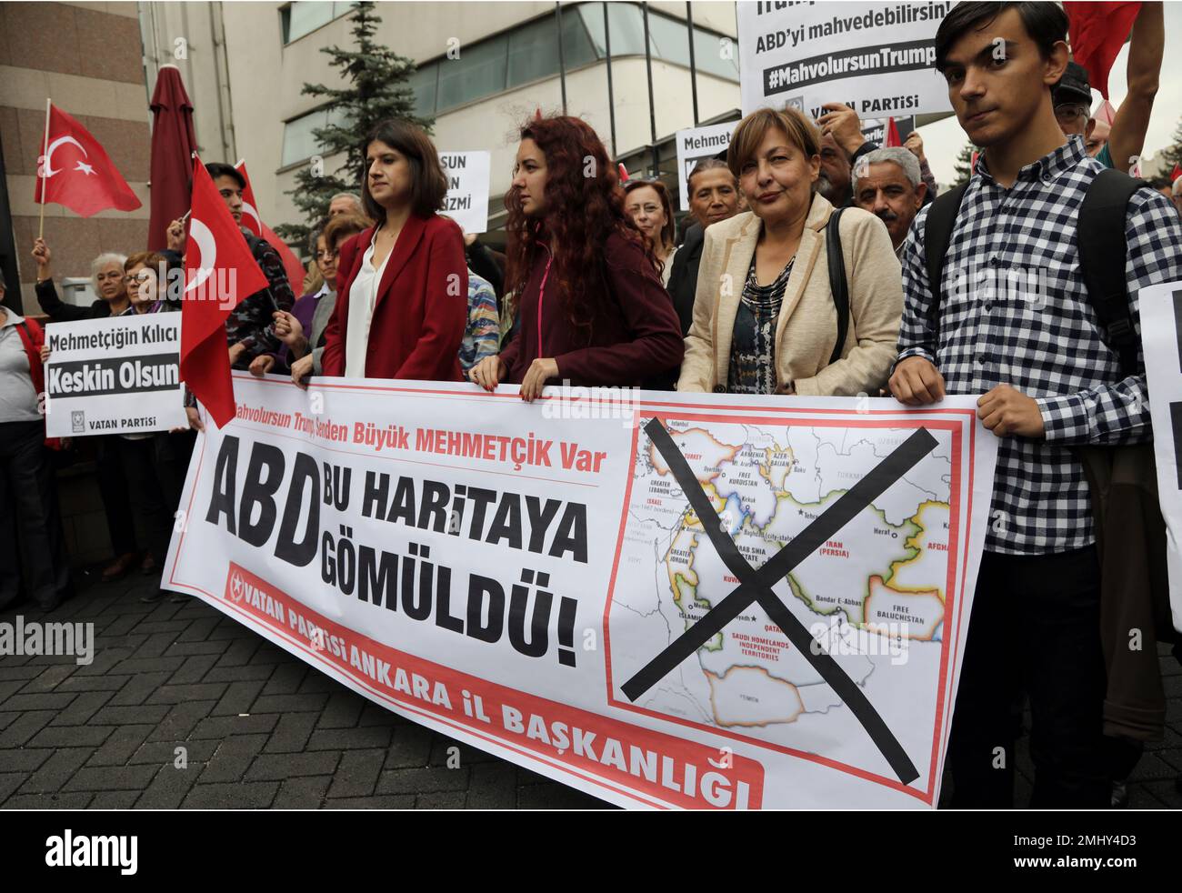 Members of a Turkish political party hold national flags and a banner ...