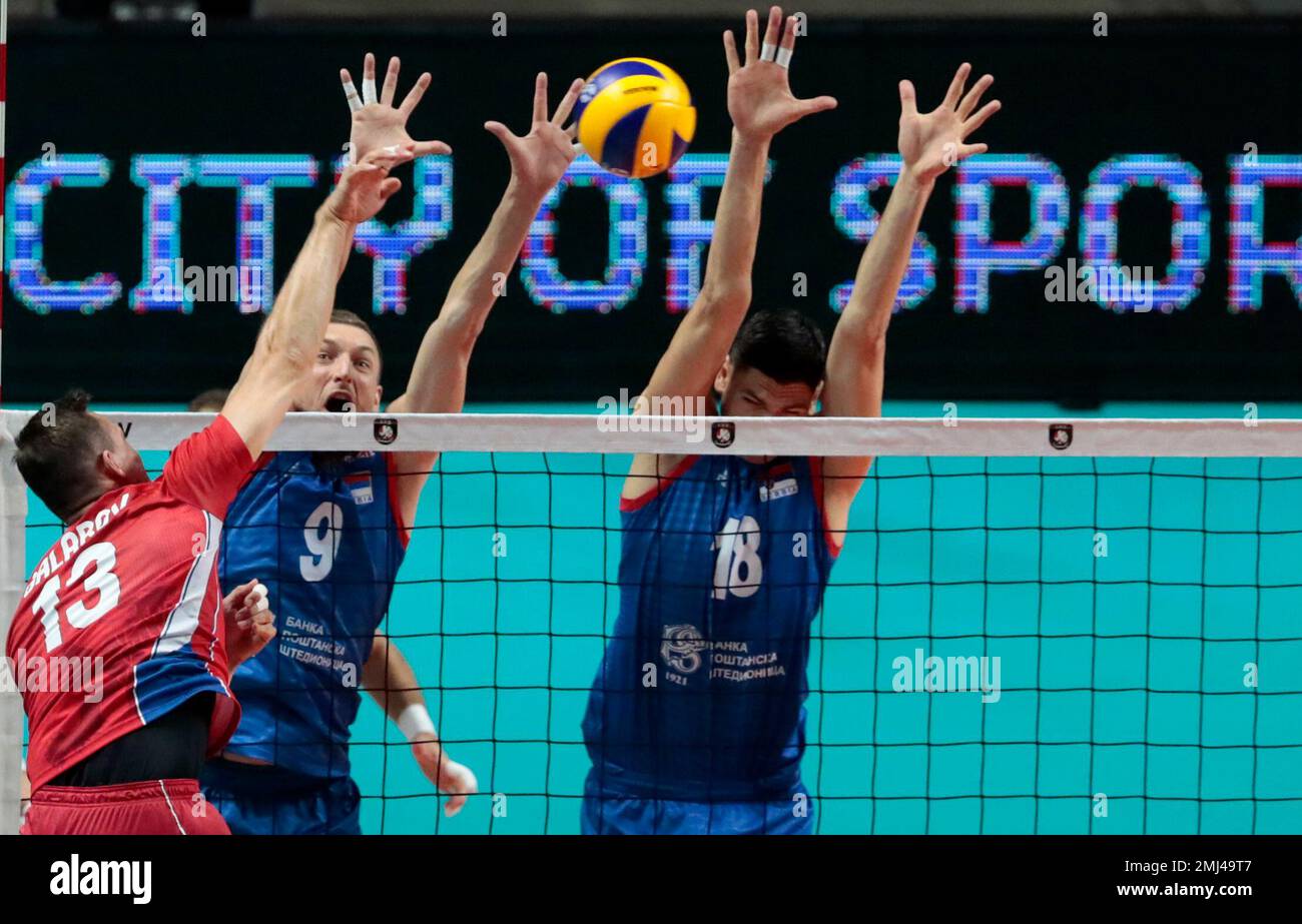 Czech Republic's Jan Galabov, left, spikes the ball as Serbia's Nikola ...