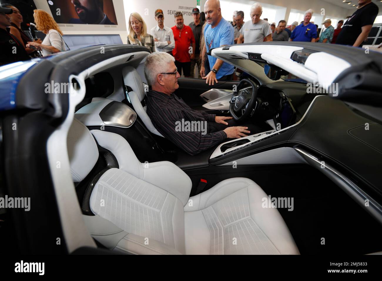 An attendee sits in the driver's seat of a 2020 Chevrolet Corvette ...