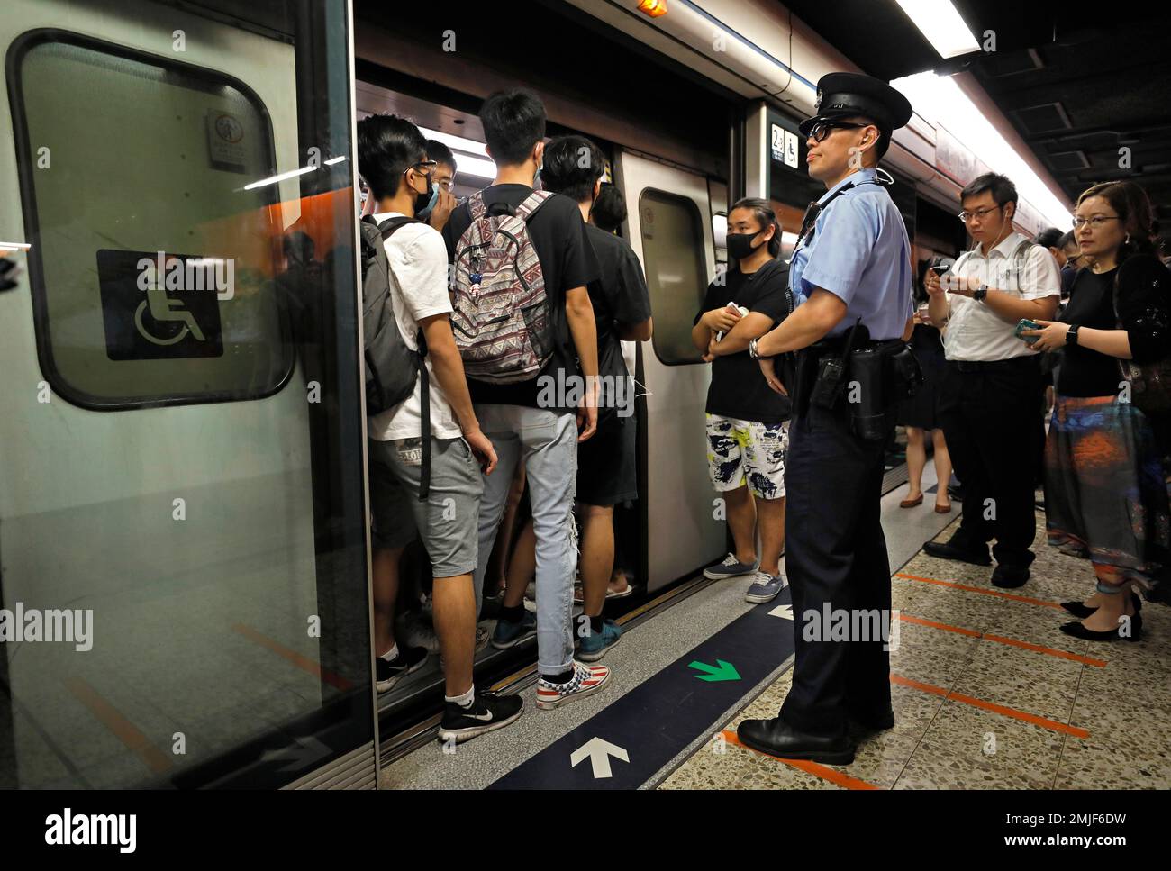 A police officer stands next to some protesters who are blocking the ...
