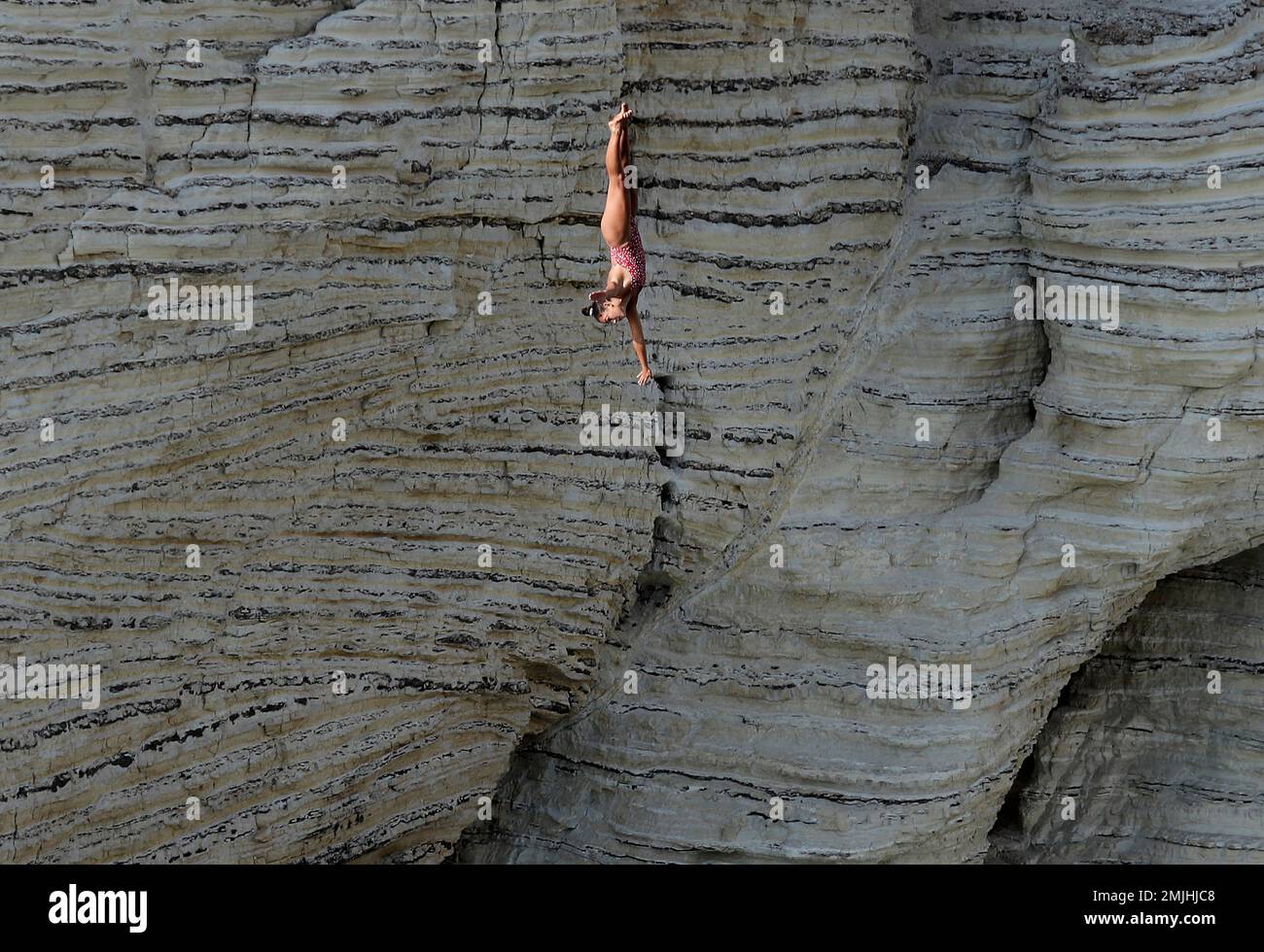 A cliff diver jumps from the landmark Raouche sea rock, during the Red ...