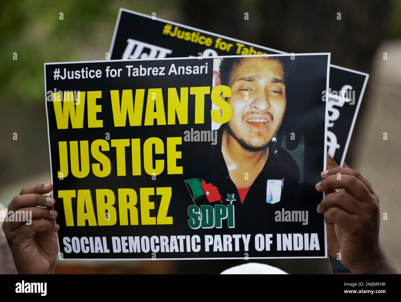 An Indian man holds a placard condemning recent mob lynching of Muslim ...