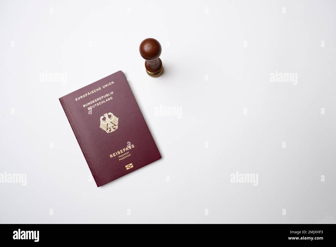 Ein deutscher Pass auf weißem Hintergrund und ein Stempel daneben ...