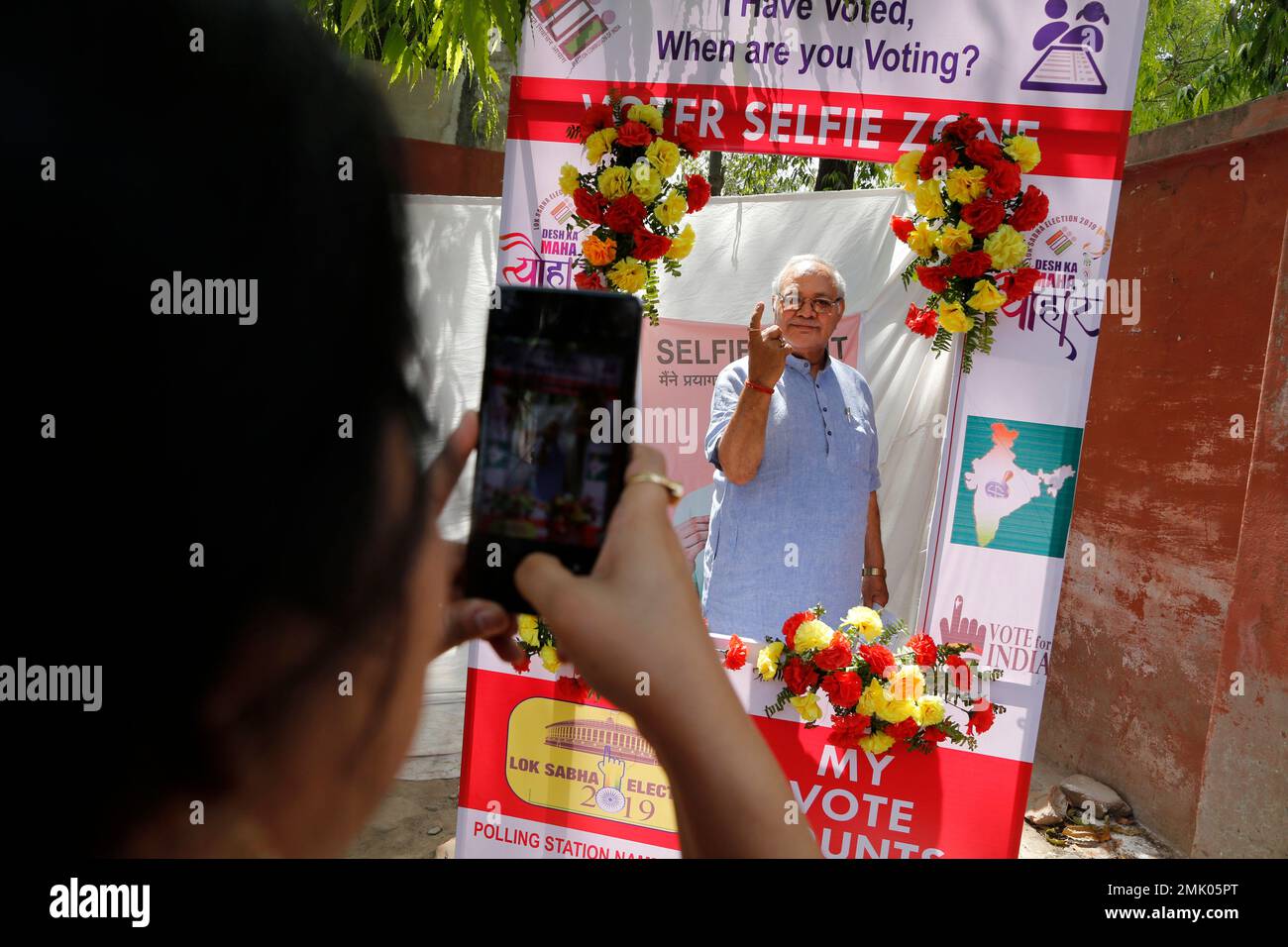 An Indian man displays the indelible ink mark on his finger as he poses ...