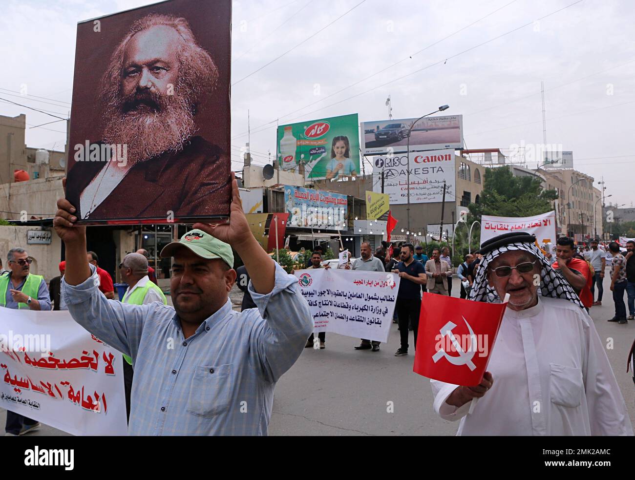 An Iraqi man holds a portrait of the communist icon Karl Marx, while ...