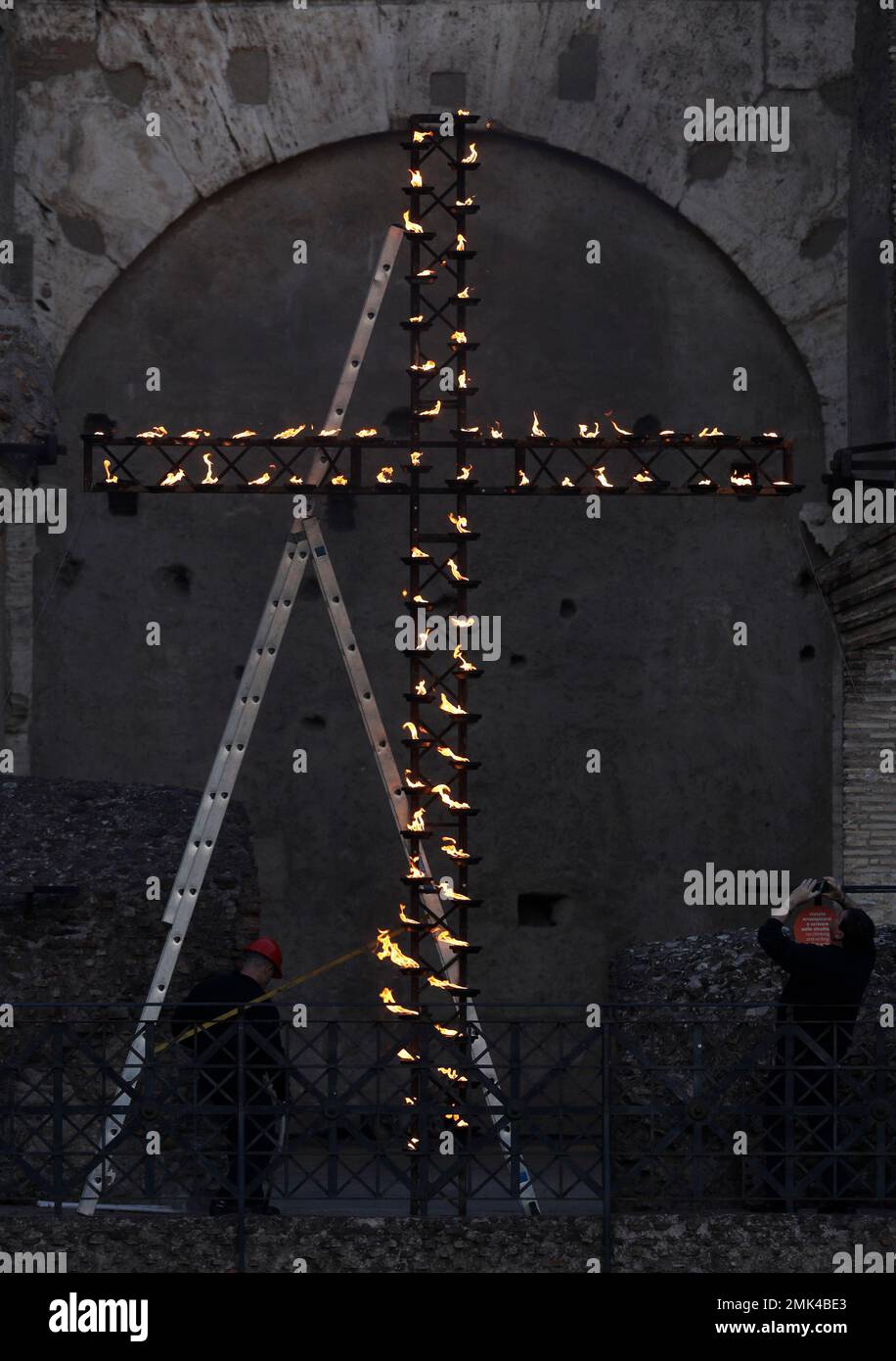 Workers light up the cross at the start of the Via Crucis (Way of the ...
