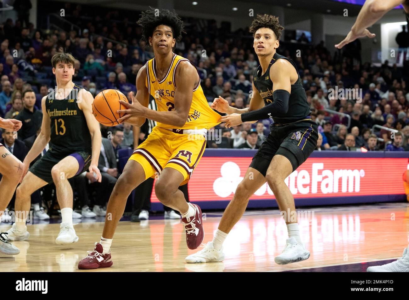 Northwestern guard Ty Berry, right, grabs the jersey of Minnesota ...
