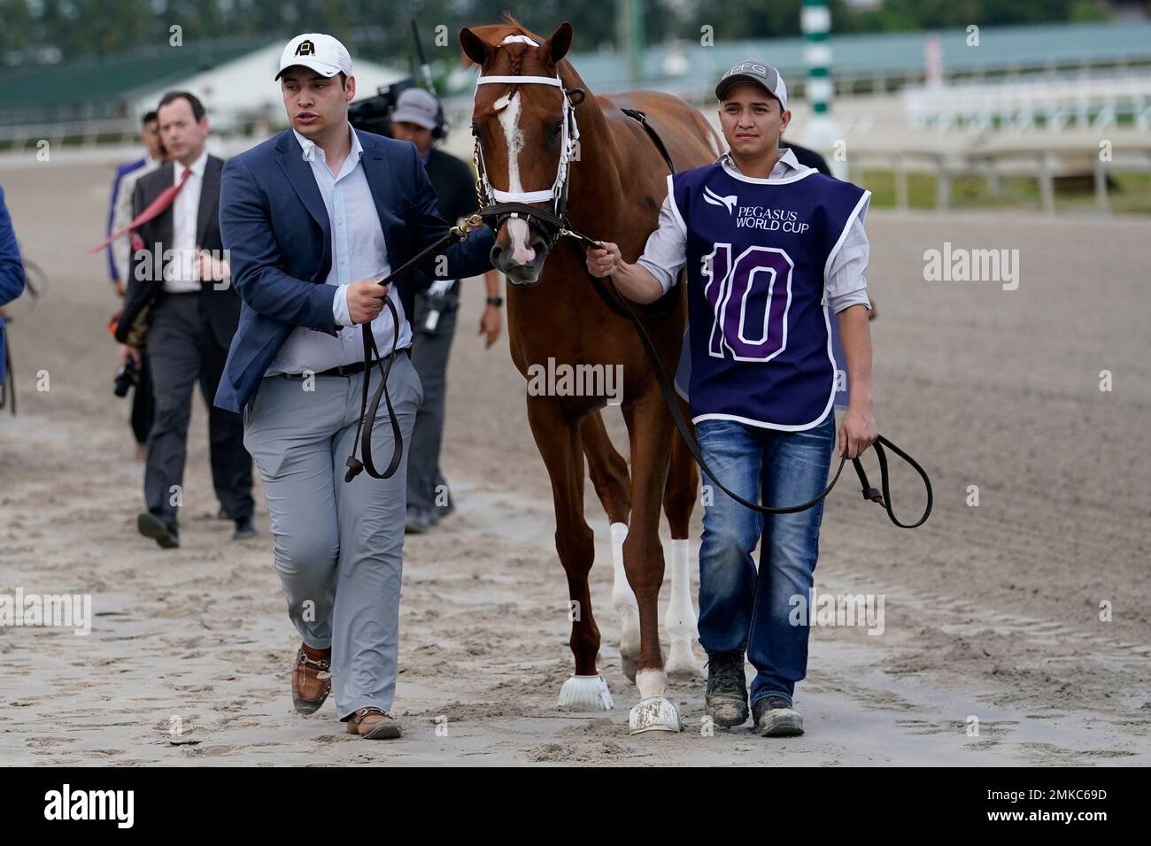 Trainer Brad Cox, left, walks with the Cyberknife before the Pegasus ...