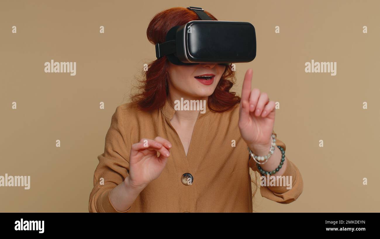 Rothaarige Frau, die einen Headset-Helm verwendet, um online ...