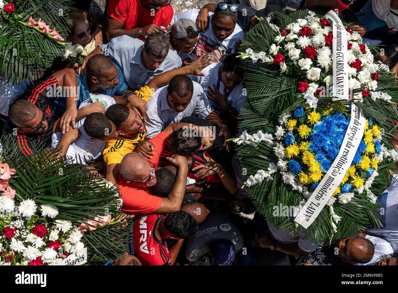 Friends and relatives of the late Christian Esmerio Candido embrace ...