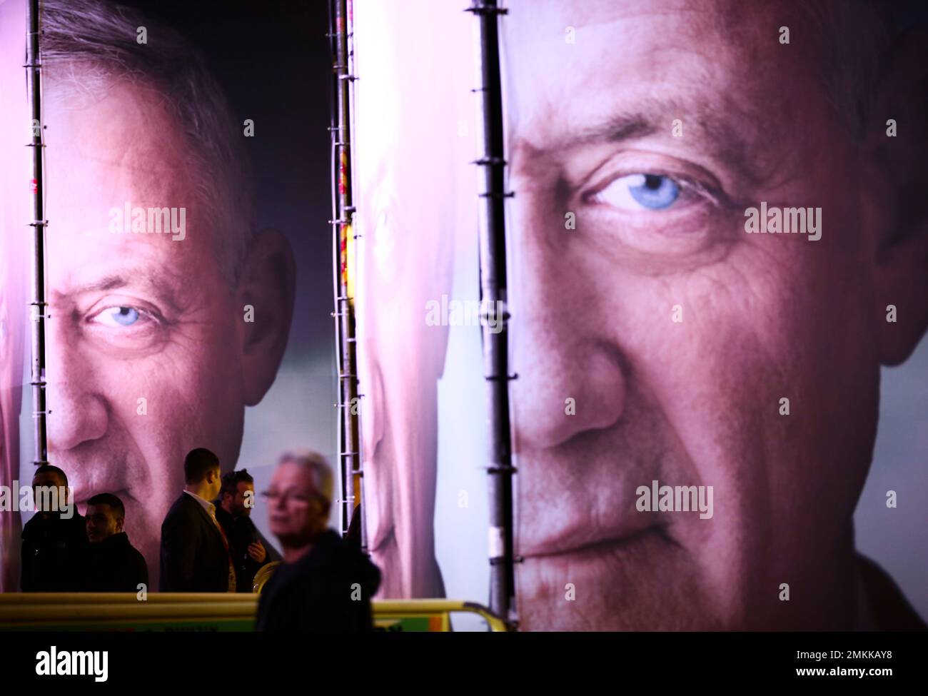 People walk by posters of retired Israeli military chief Benny Gantz ...