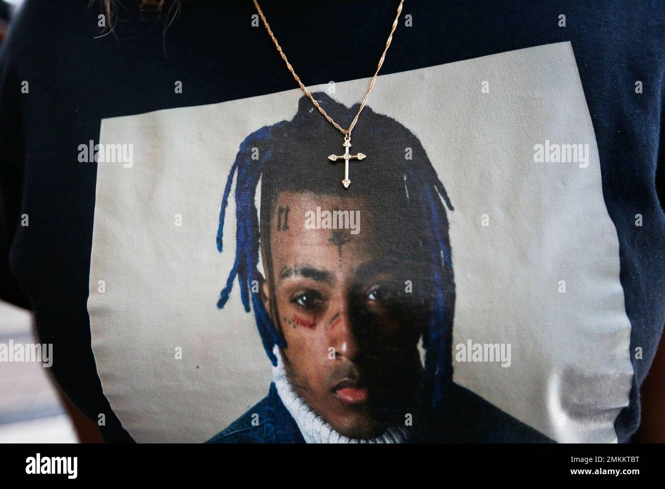 FILE- In this June 27, 2018, file photo a fan wears a cross around her ...