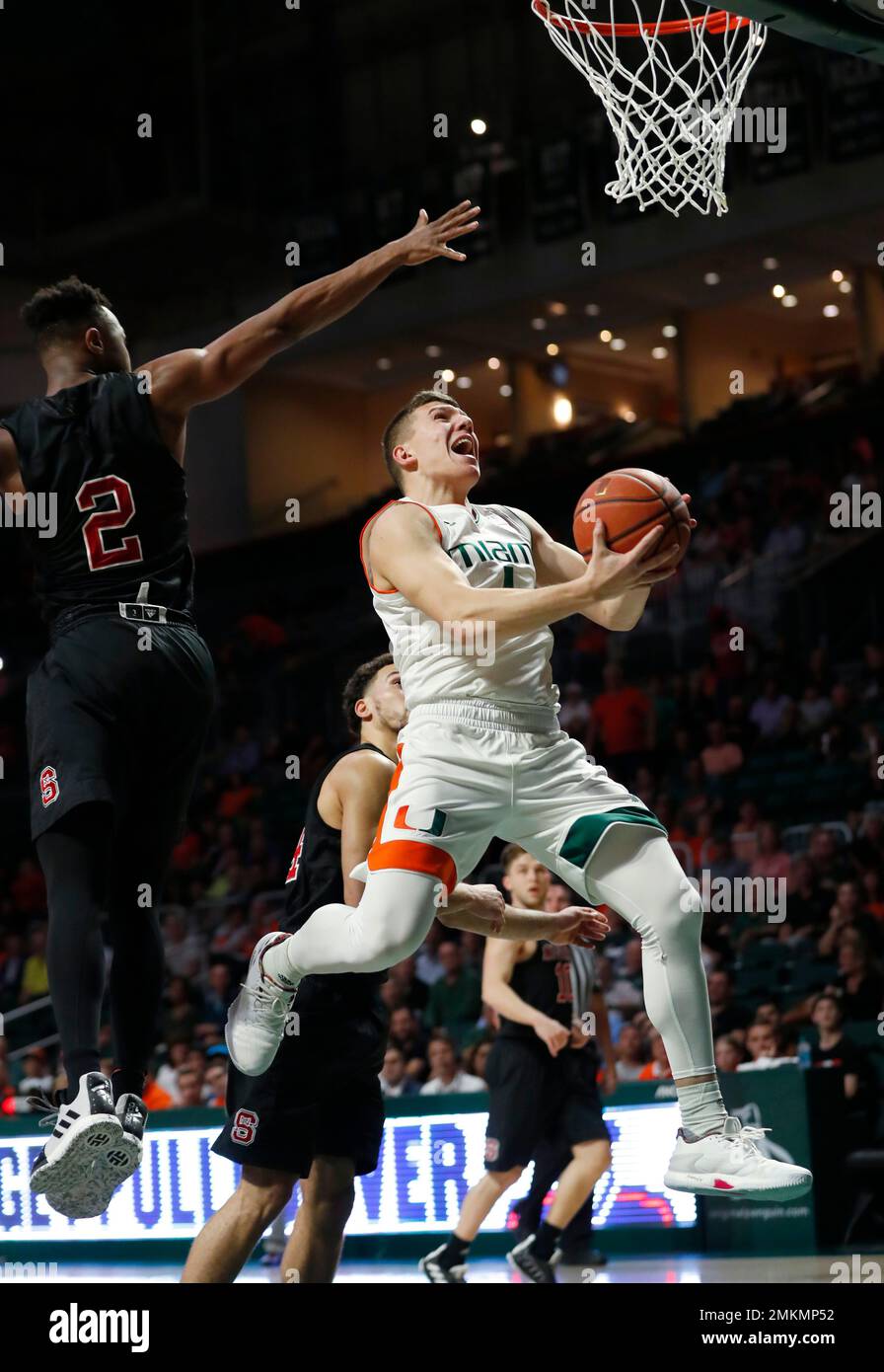 Miami guard Dejan Vasiljevic goes up for a shot against NC State guard ...