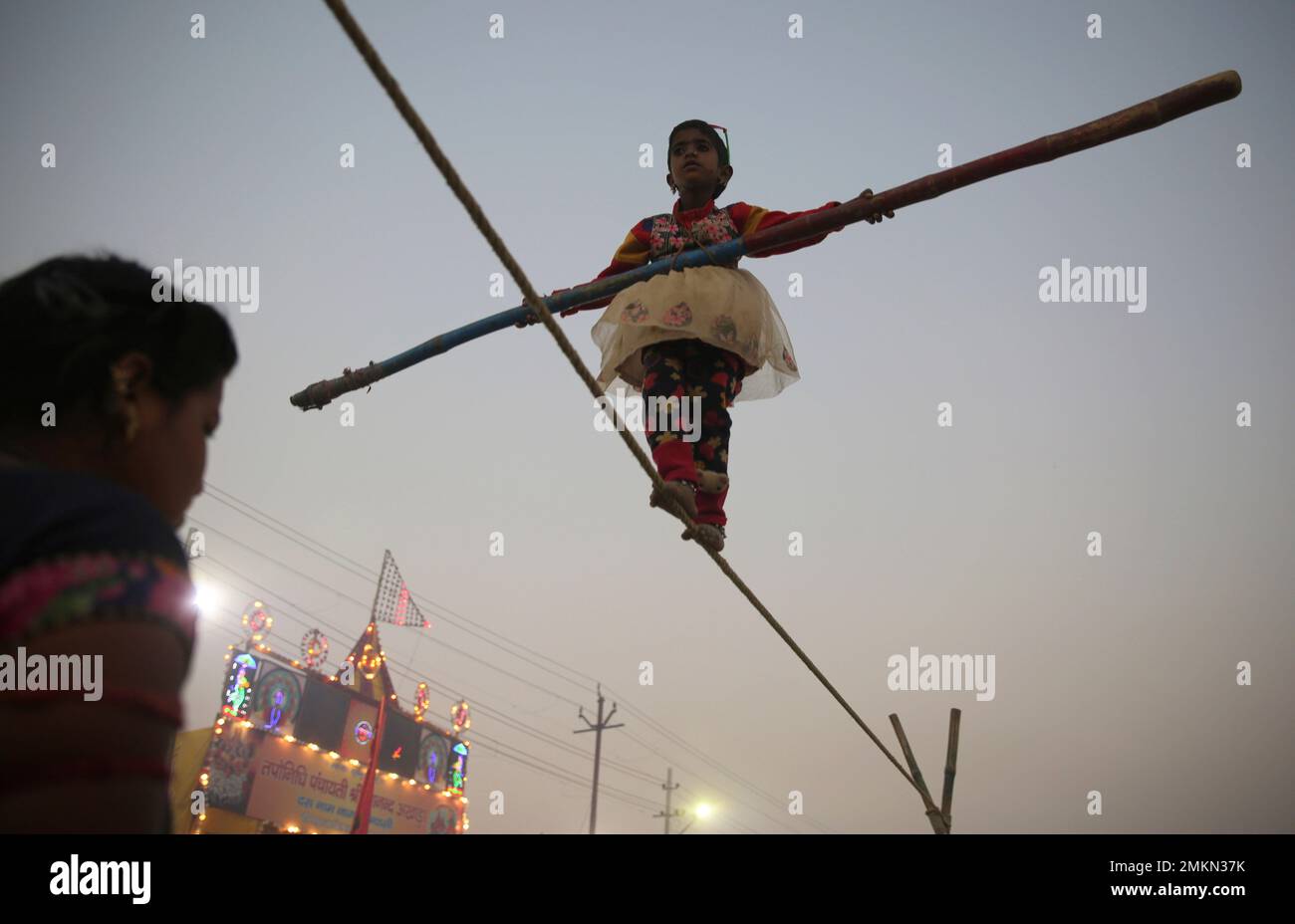 An Indian child performer walks on a rope as she entertains devotees at ...