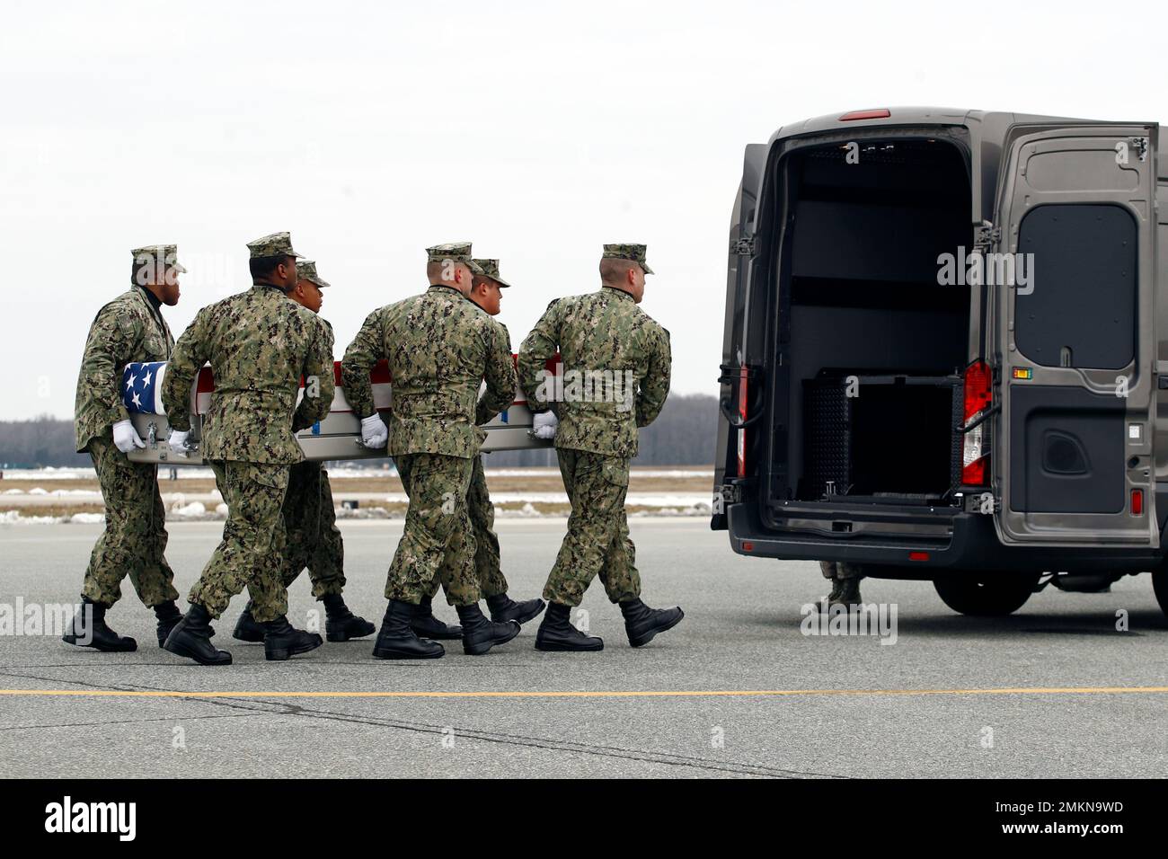A U.S. Navy carry team moves a transfer case containing the remains of ...
