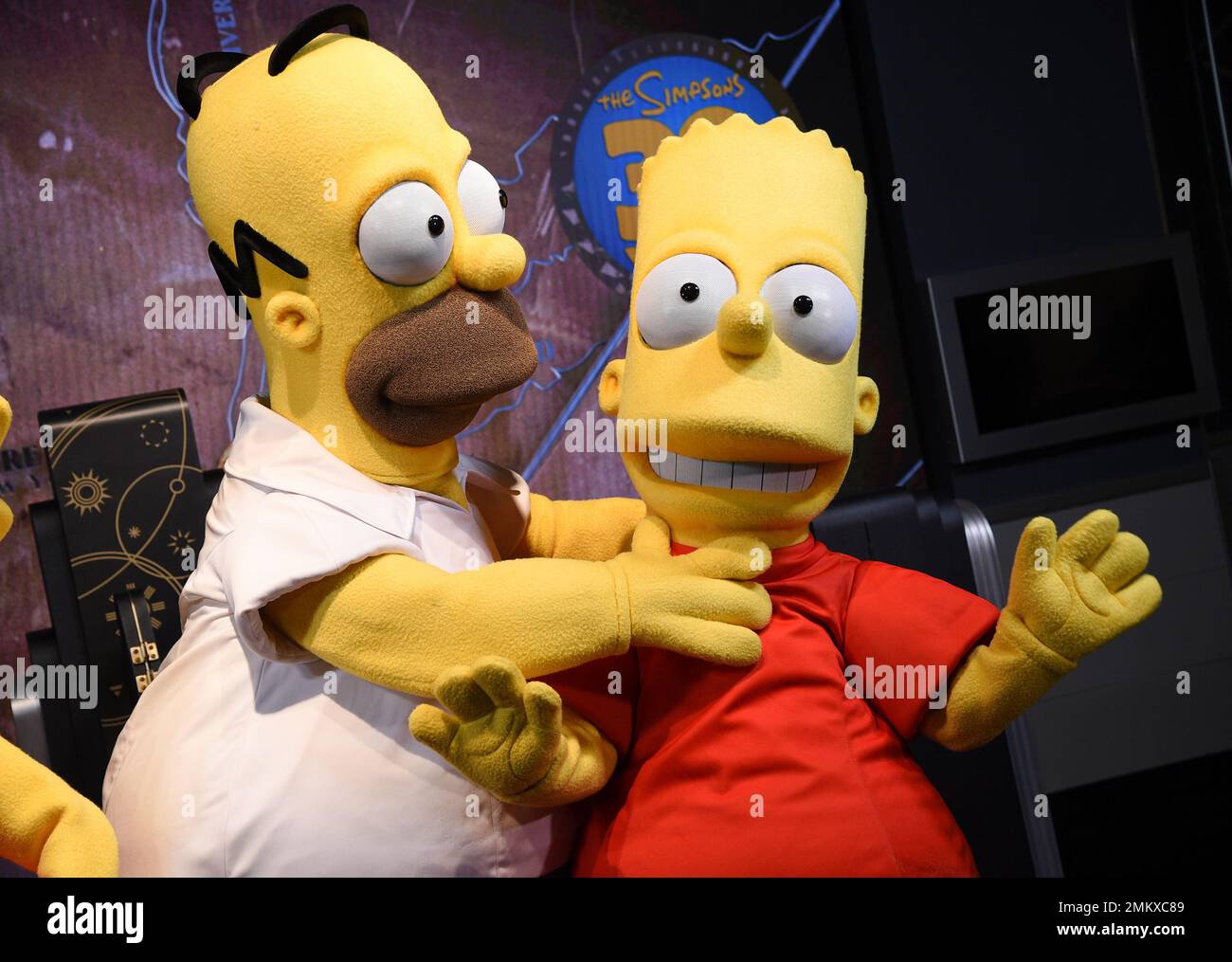 Costume characters Homer Simpson, left, and Bart Simpson participate in ...