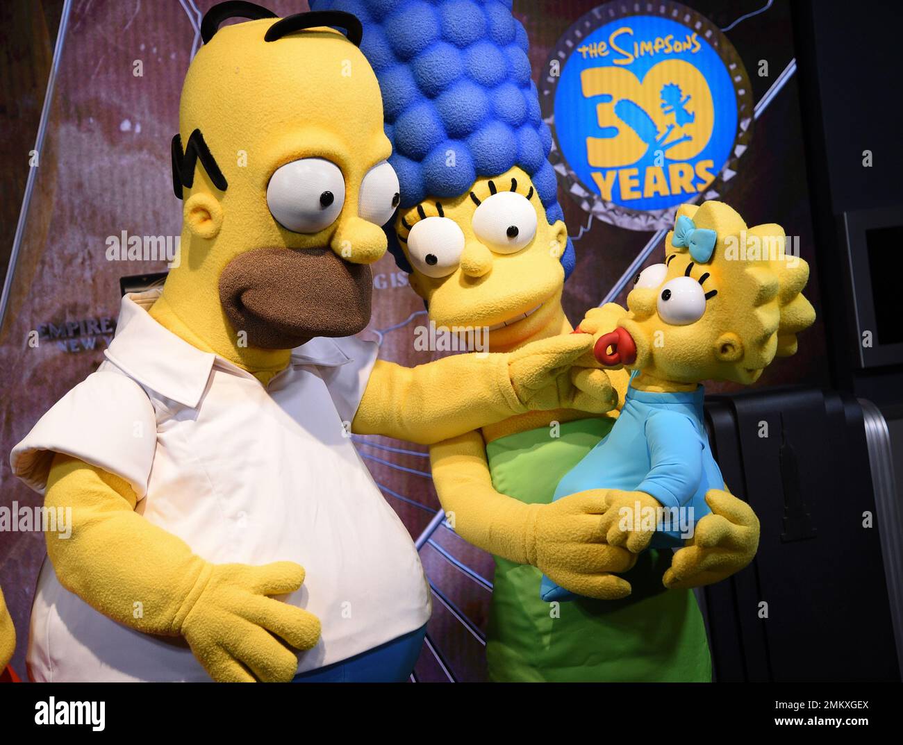 Costumed characters Homer Simpson, left, Marge Simpson and Maggie ...