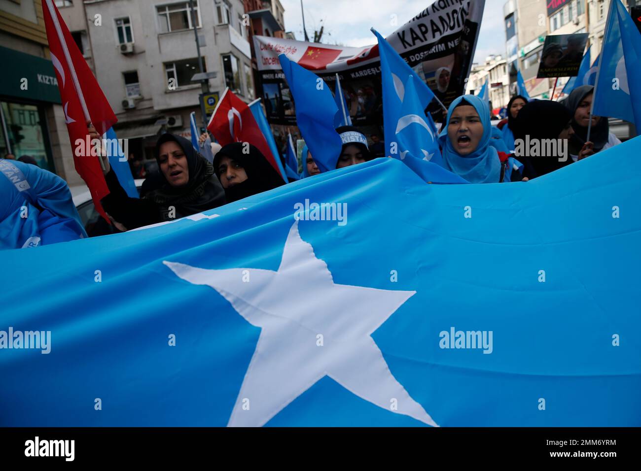People from the Uighur community living in Turkey carrying flags of ...