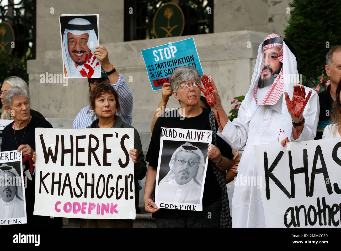 People hold signs at the Embassy of Saudi Arabia during protest about ...