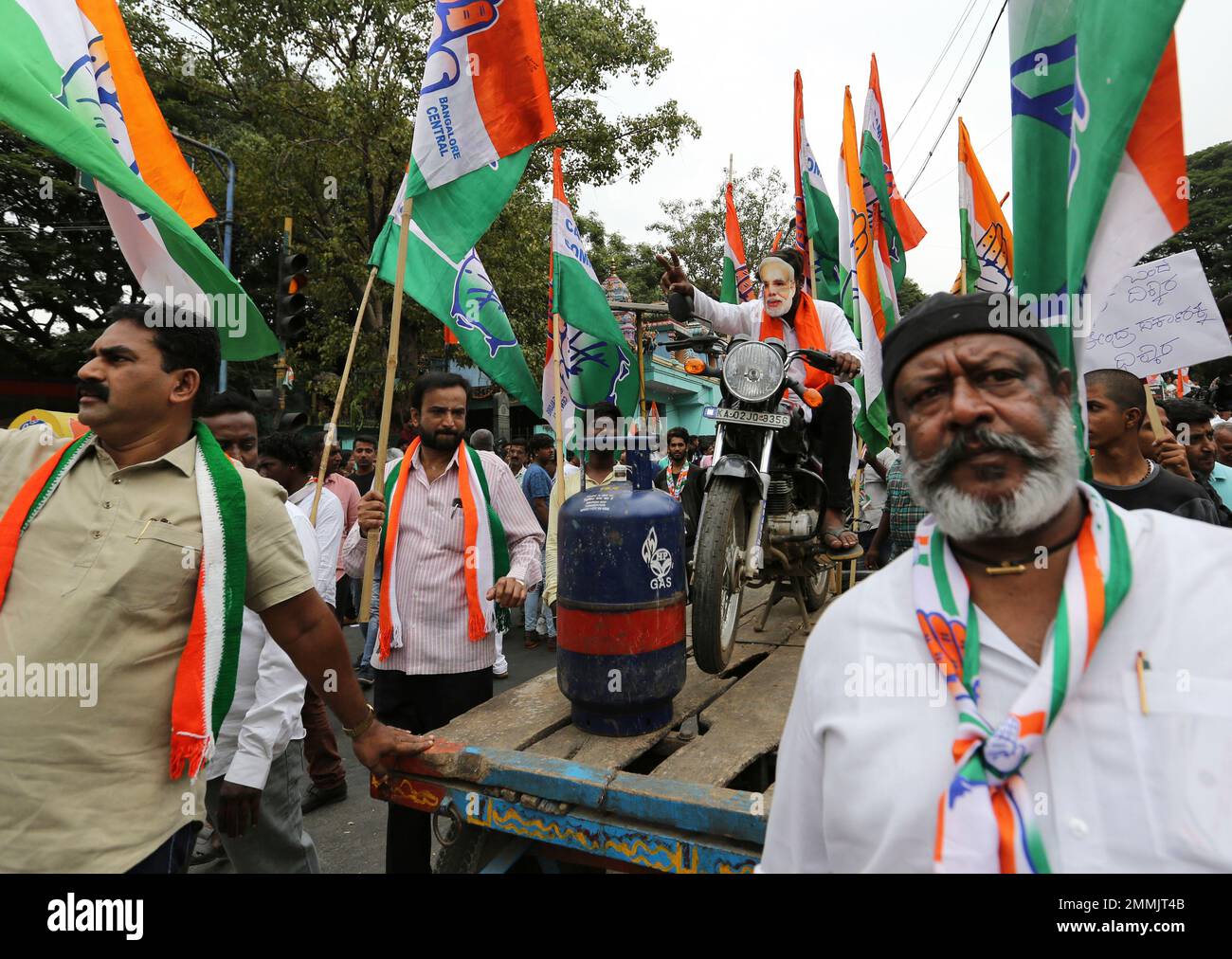 A Congress party supporter wears a mask of India's Prime Minister ...