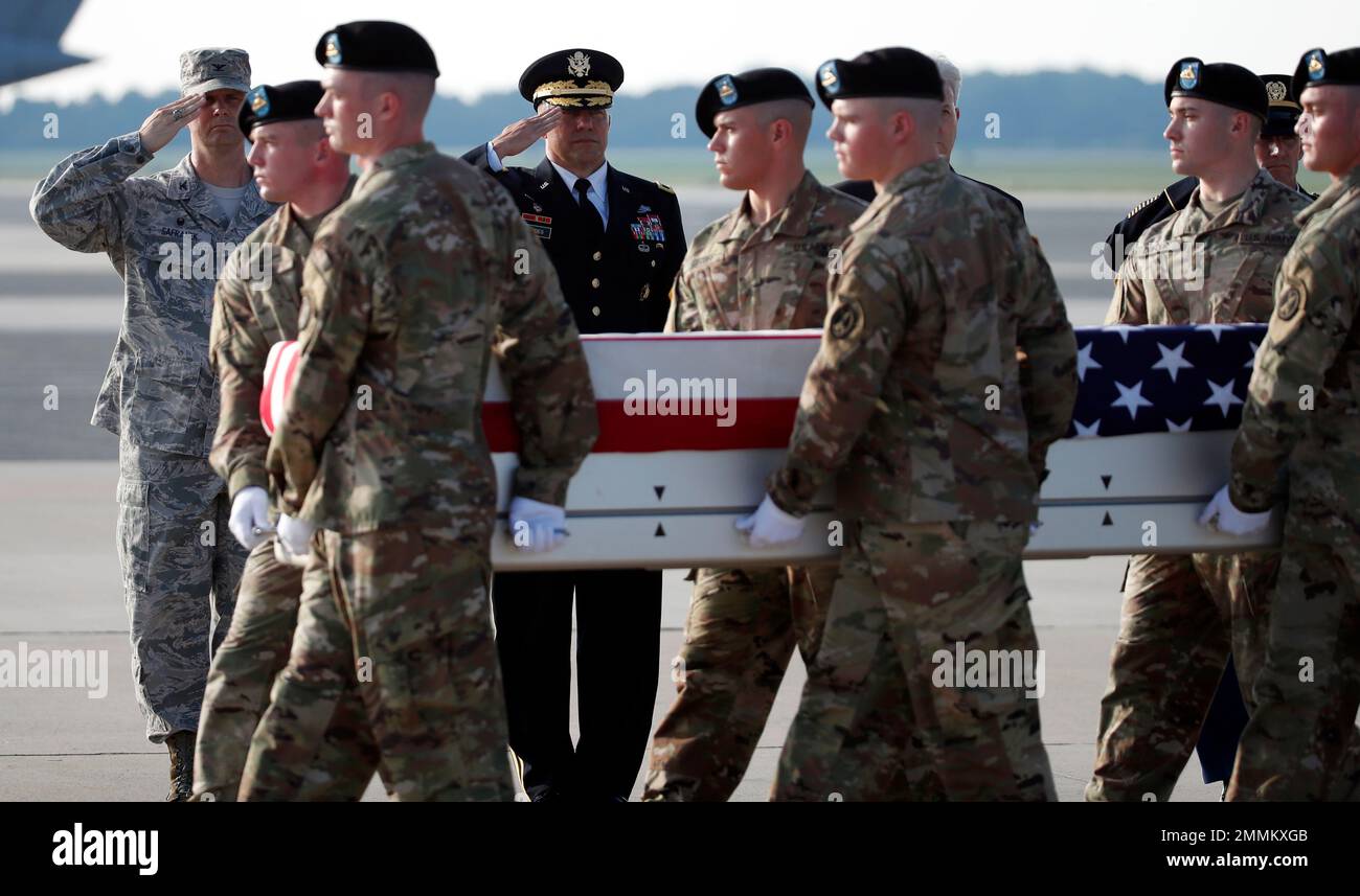 An Army carry team moves a transfer case containing the remains of U.S ...