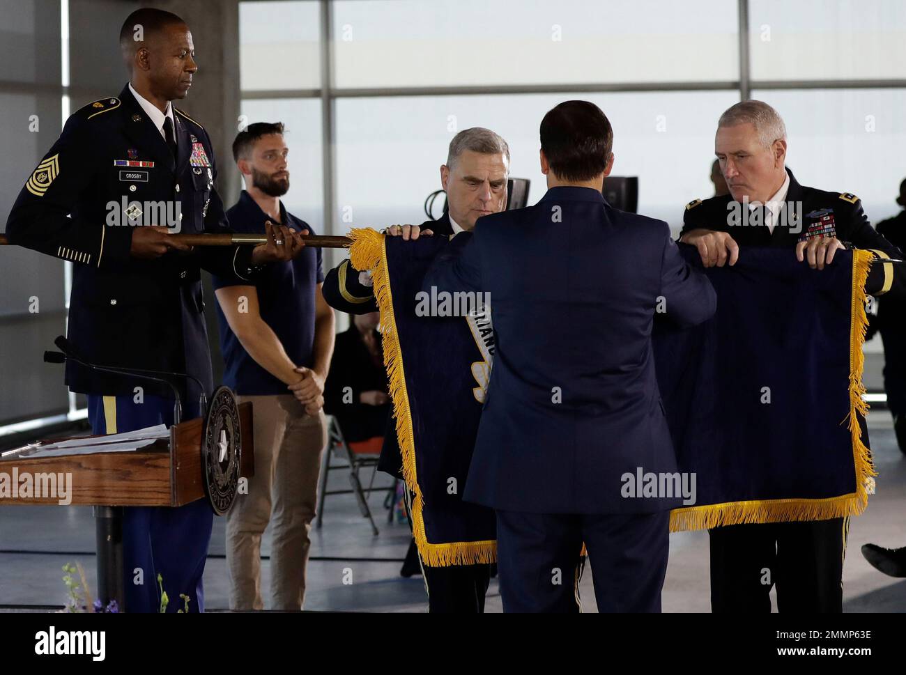 Command Sgt. Maj. Michael Crosby, left, unfurls the new flag during an ...