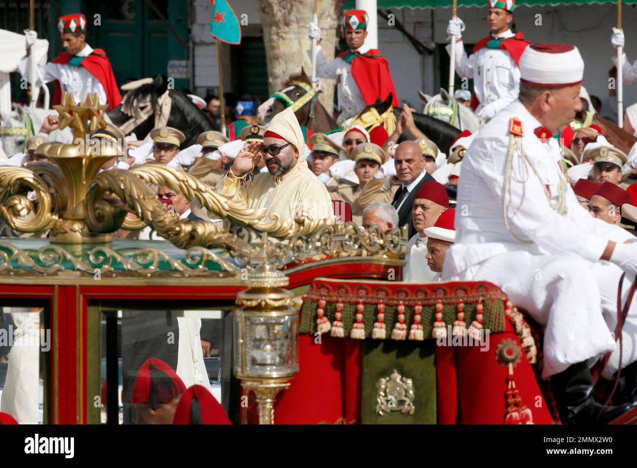 Morocco's King Mohammed VI waves to the crowd as he stands in a limousine during a ceremony at ...