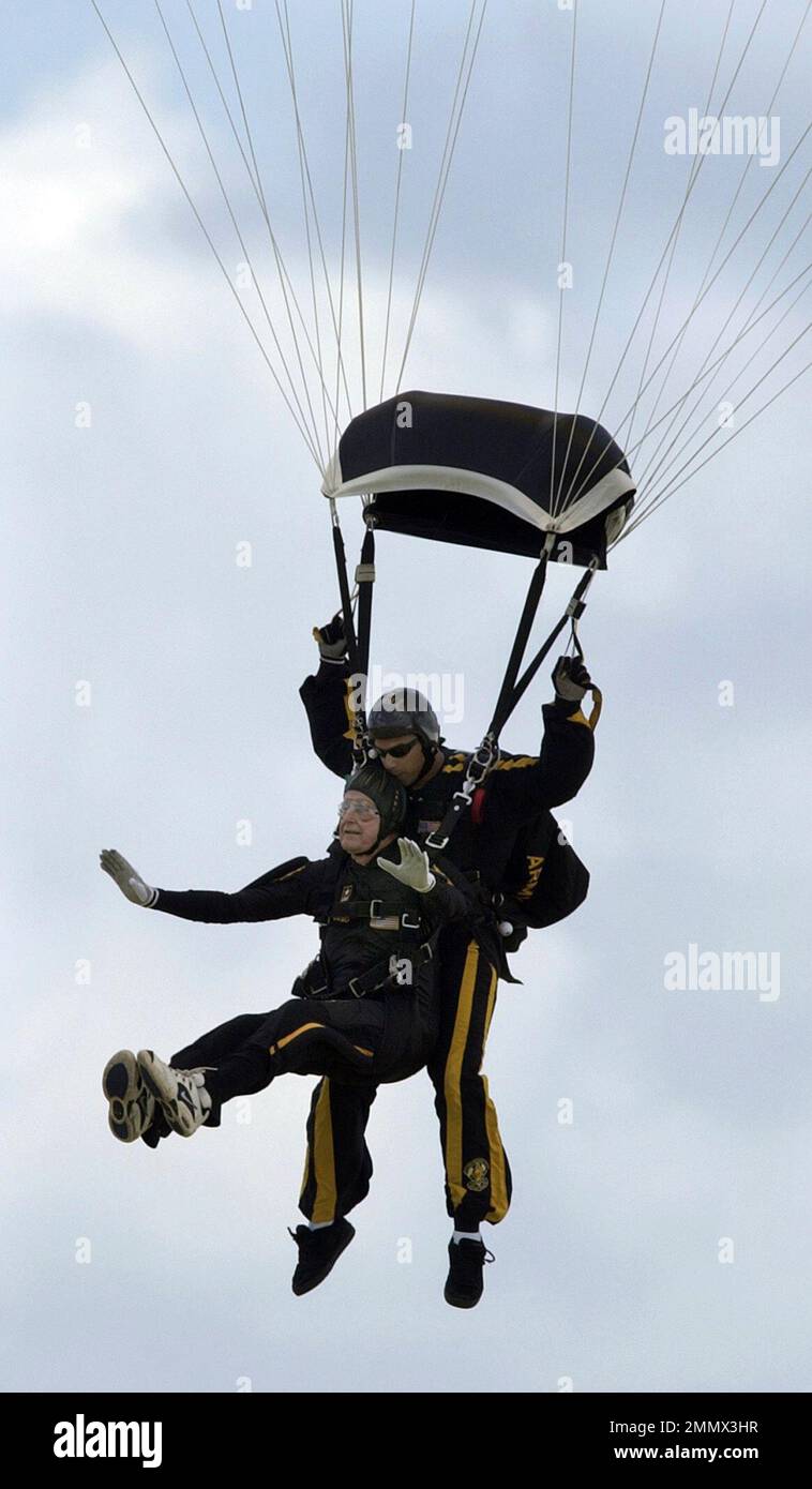 Former President George Bush parachutes to his landing after a tandem ...