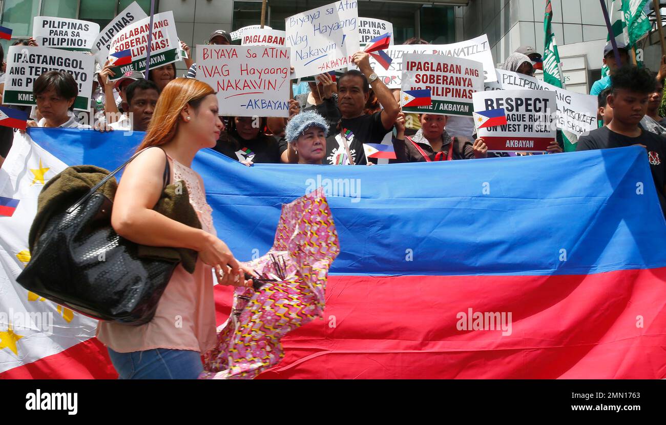 Protesters display placards and a Philippine flag during a rally at the ...