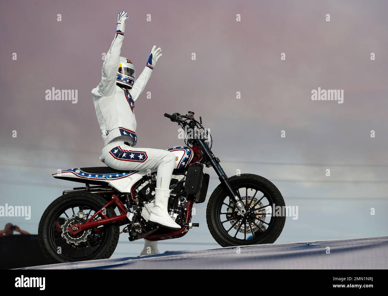 Travis Pastrana celebrates after jumping a row of crushed cars on a ...