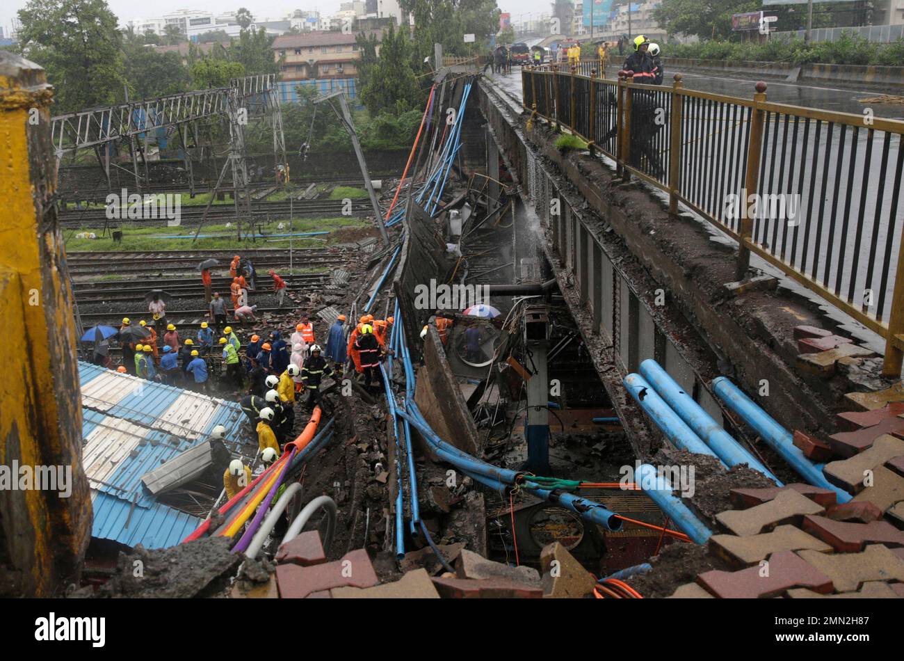 Rescuers work at the site of a pedestrian bridge that collapsed at a ...