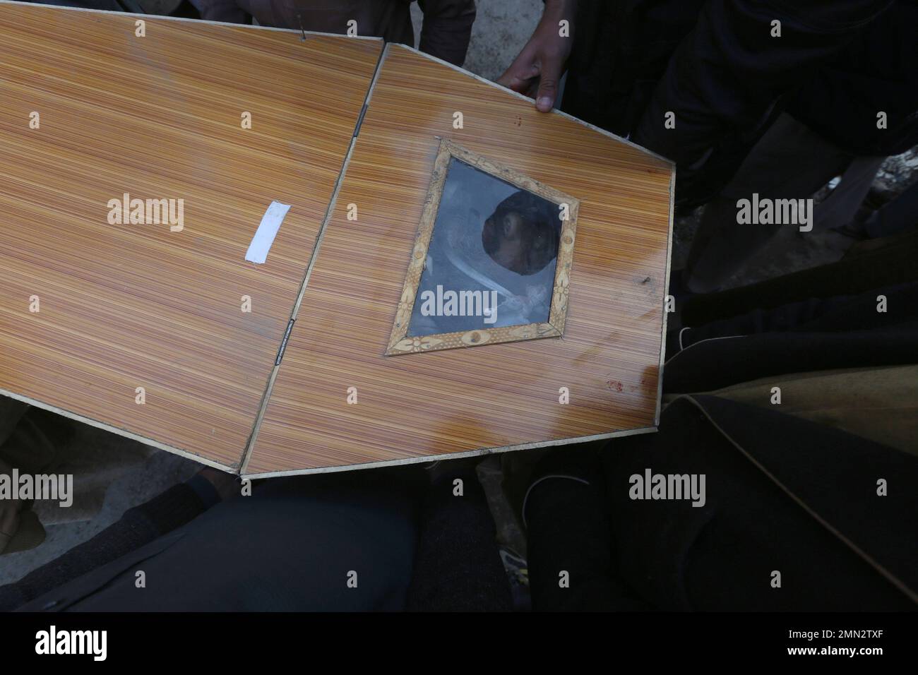 People wait for transport next to a coffin of their relative, killed in ...