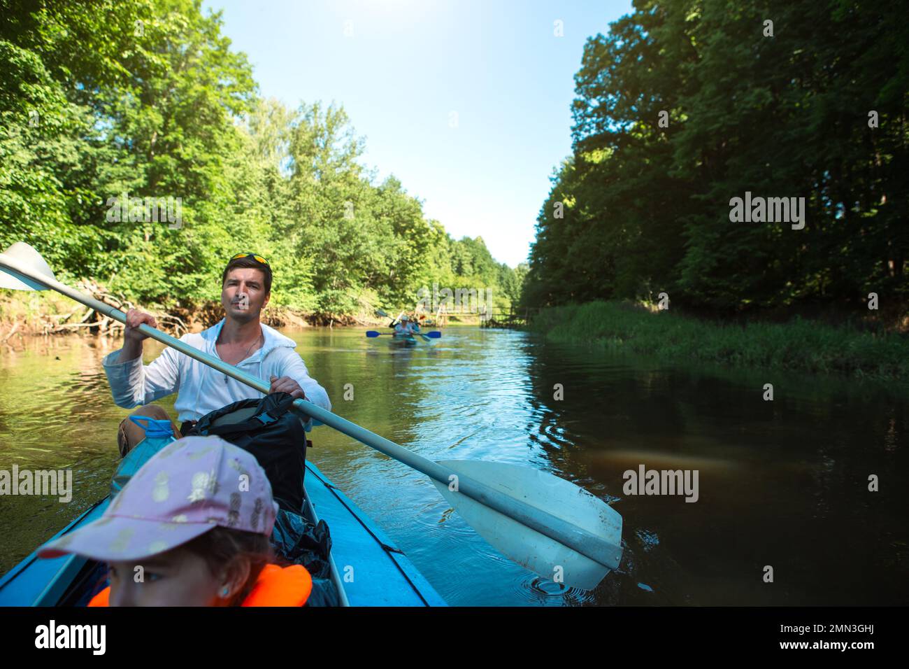 Familien-Kajakausflug. Vater und Tochter, und älteres Paar Seniorenruderboot auf dem Fluss, eine ...