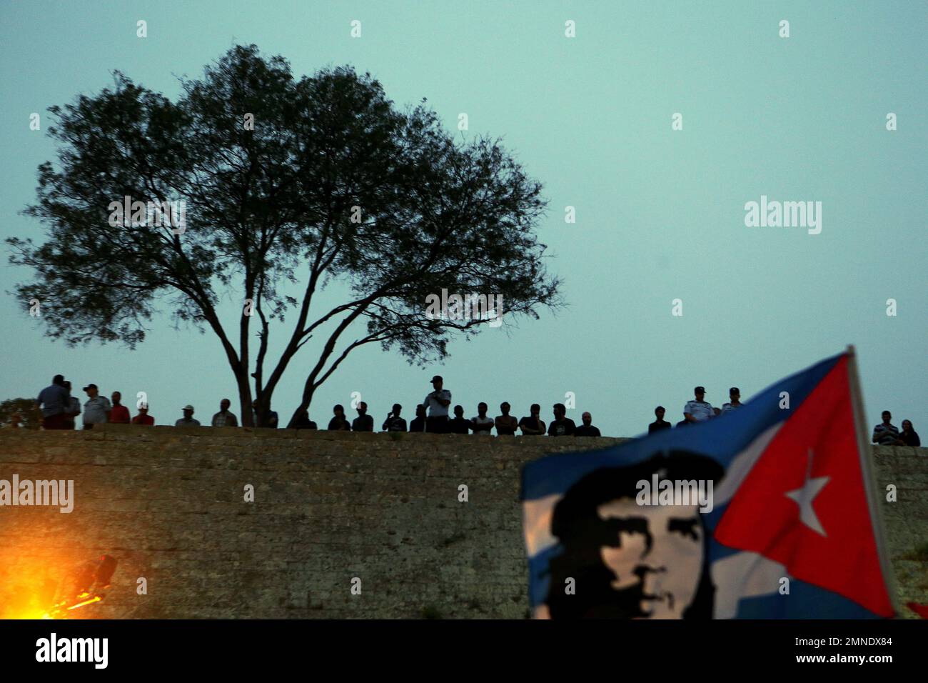 A flag of Che Guevara waves as people stand in the Turkish occupied ...