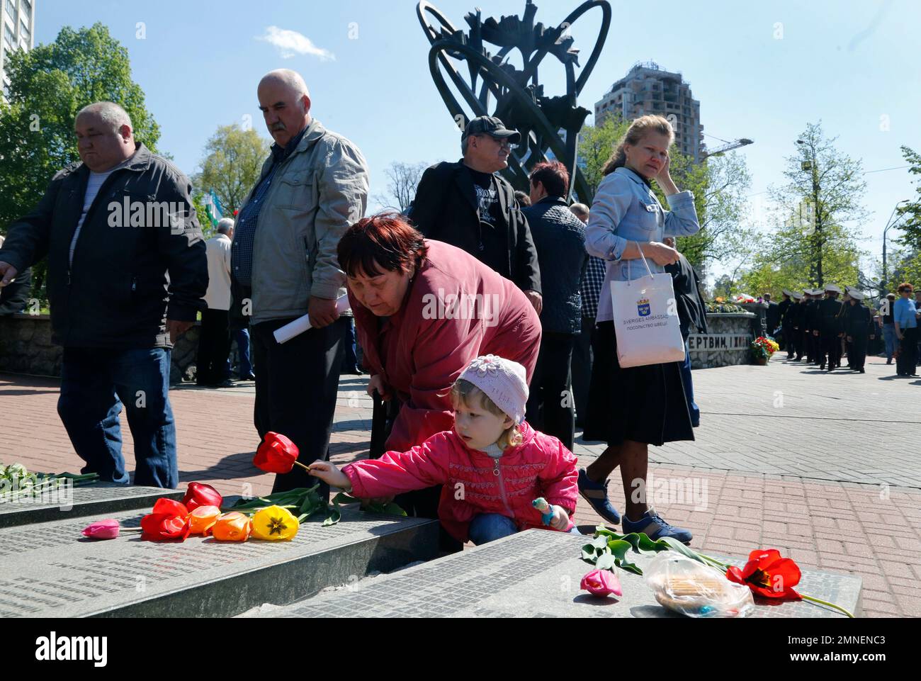 Ukrainians lay flowers by the tombstone that bears their relative's ...