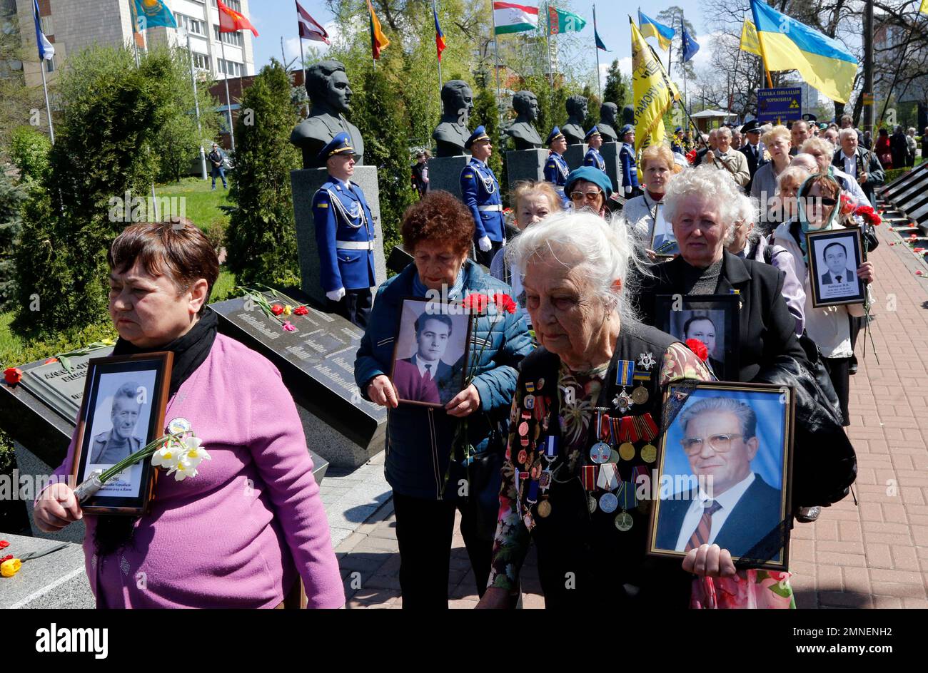 Widows of Chernobyl victims hold portraits of their husbands who died ...