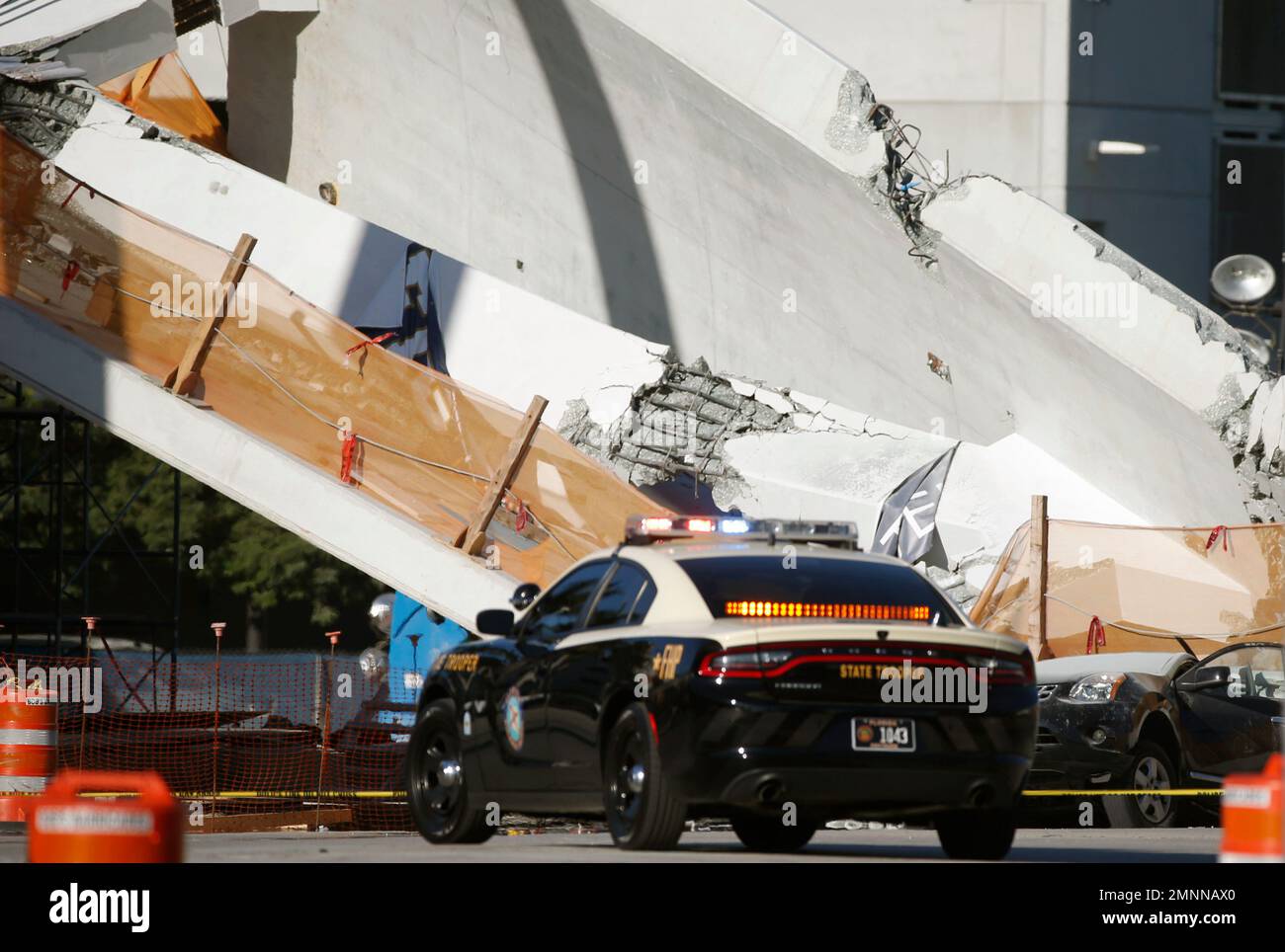 A Florida Highway Patrol vehicle is parked next to a crushed car under ...