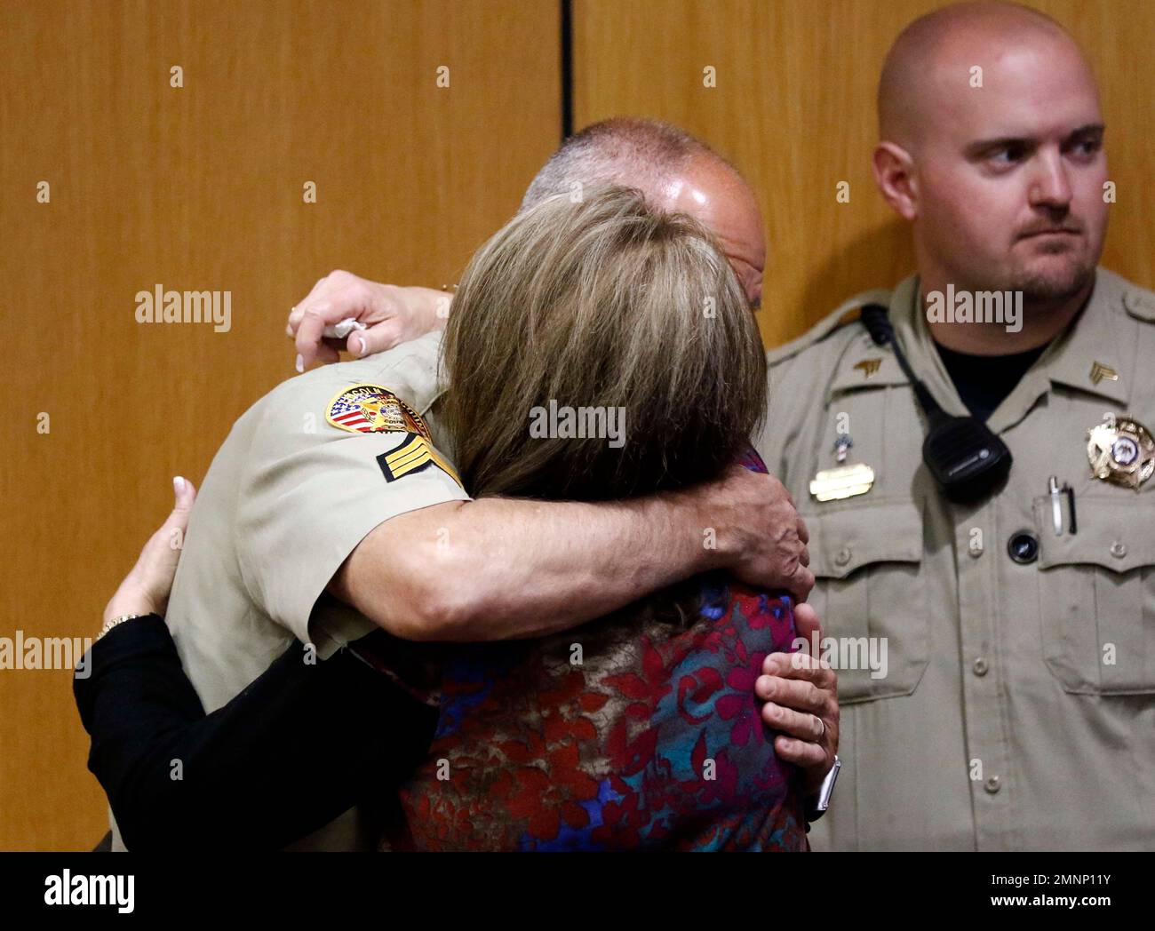 A Lincoln County deputy comforts a relative prior to the reading of the ...
