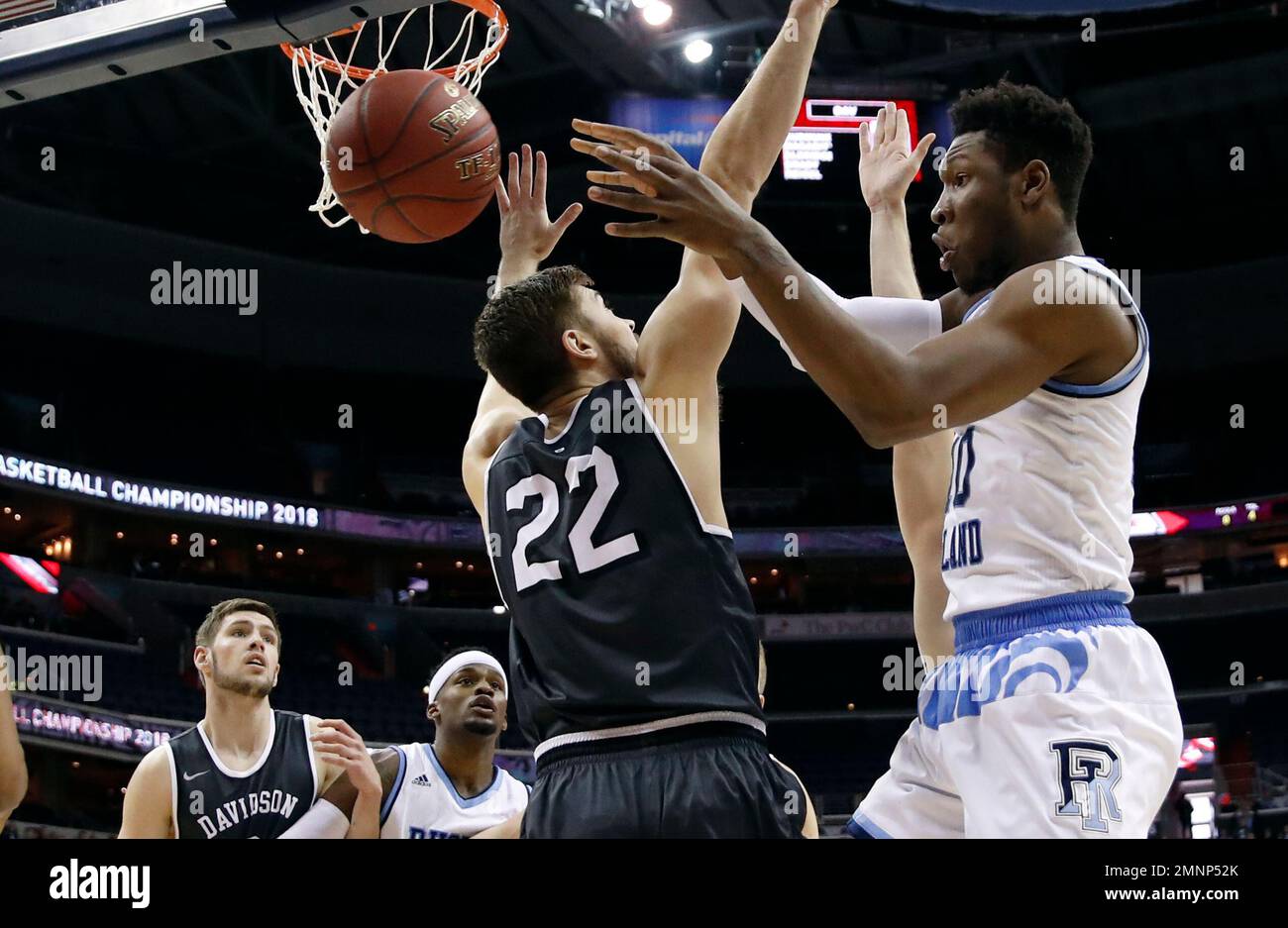 Rhode Island forward Cyril Langevine, right, passes the ball around ...