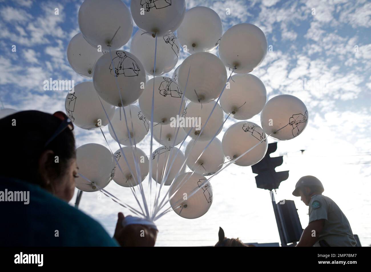 Vendors sell balloons featuring a line drawing of Pope Francis before ...